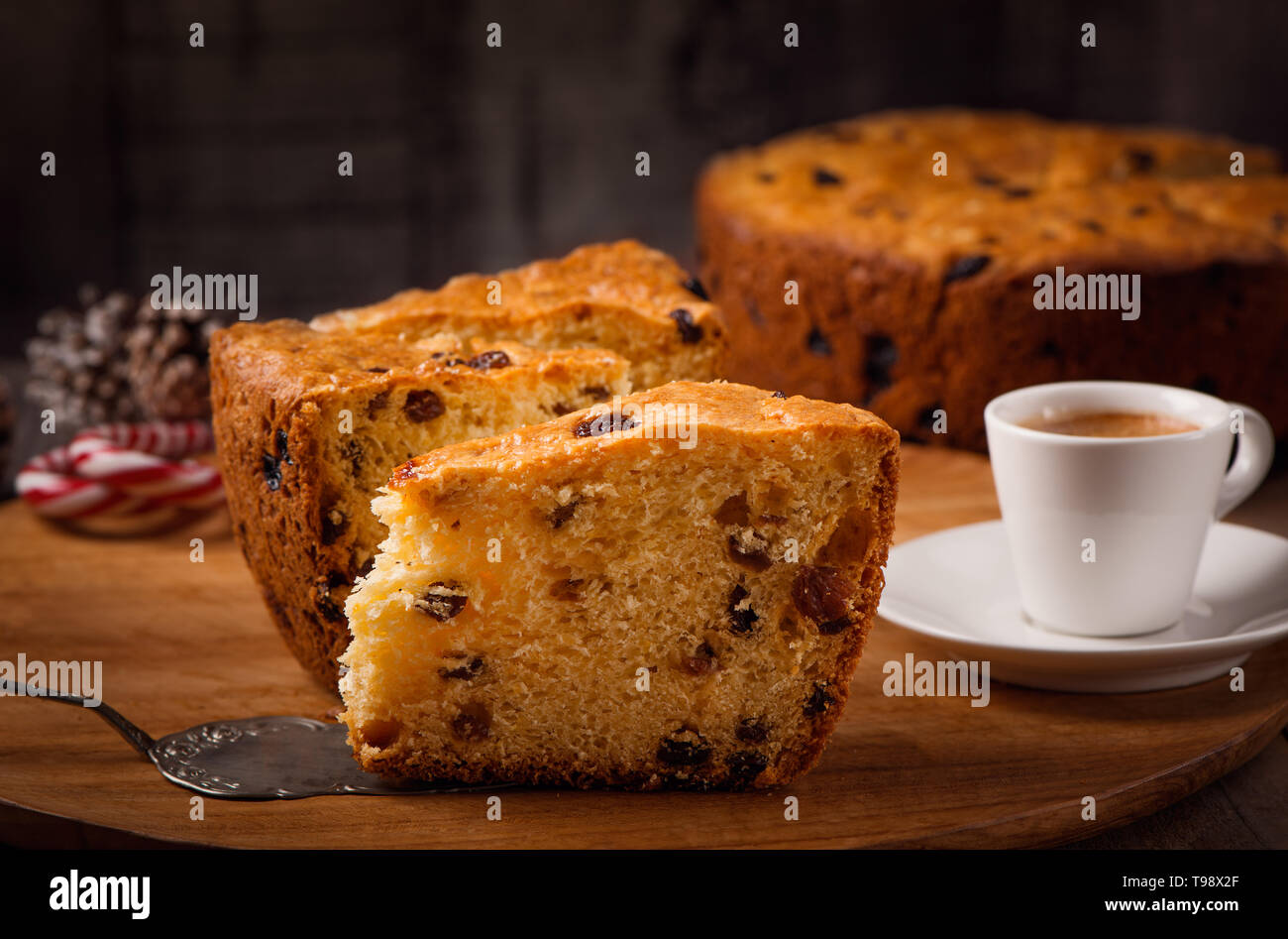 Slices of home made cake with raisins on wooden plate and white coffee ...