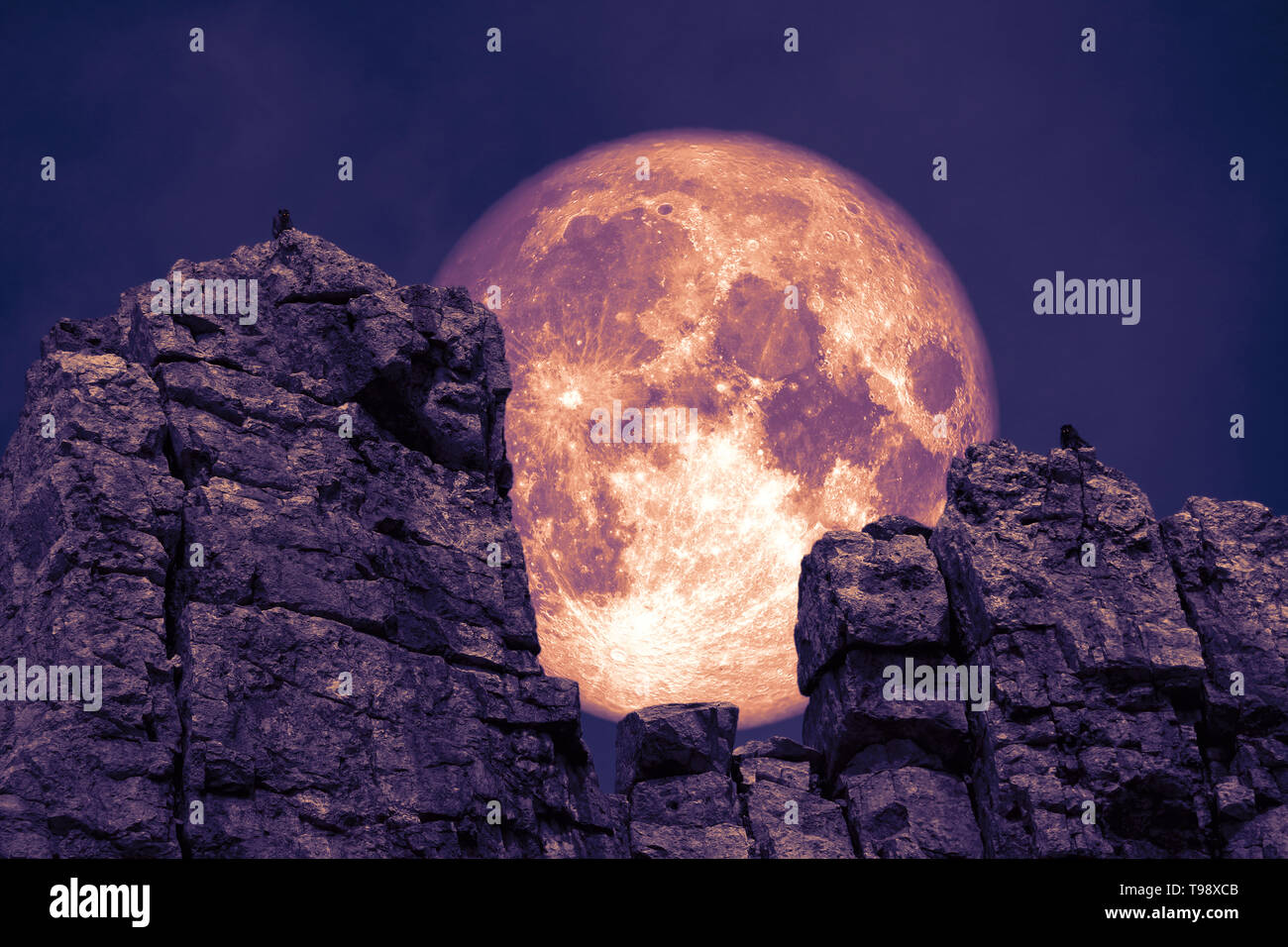 dark purple moon back over stone and monsters on rock between cliff ...