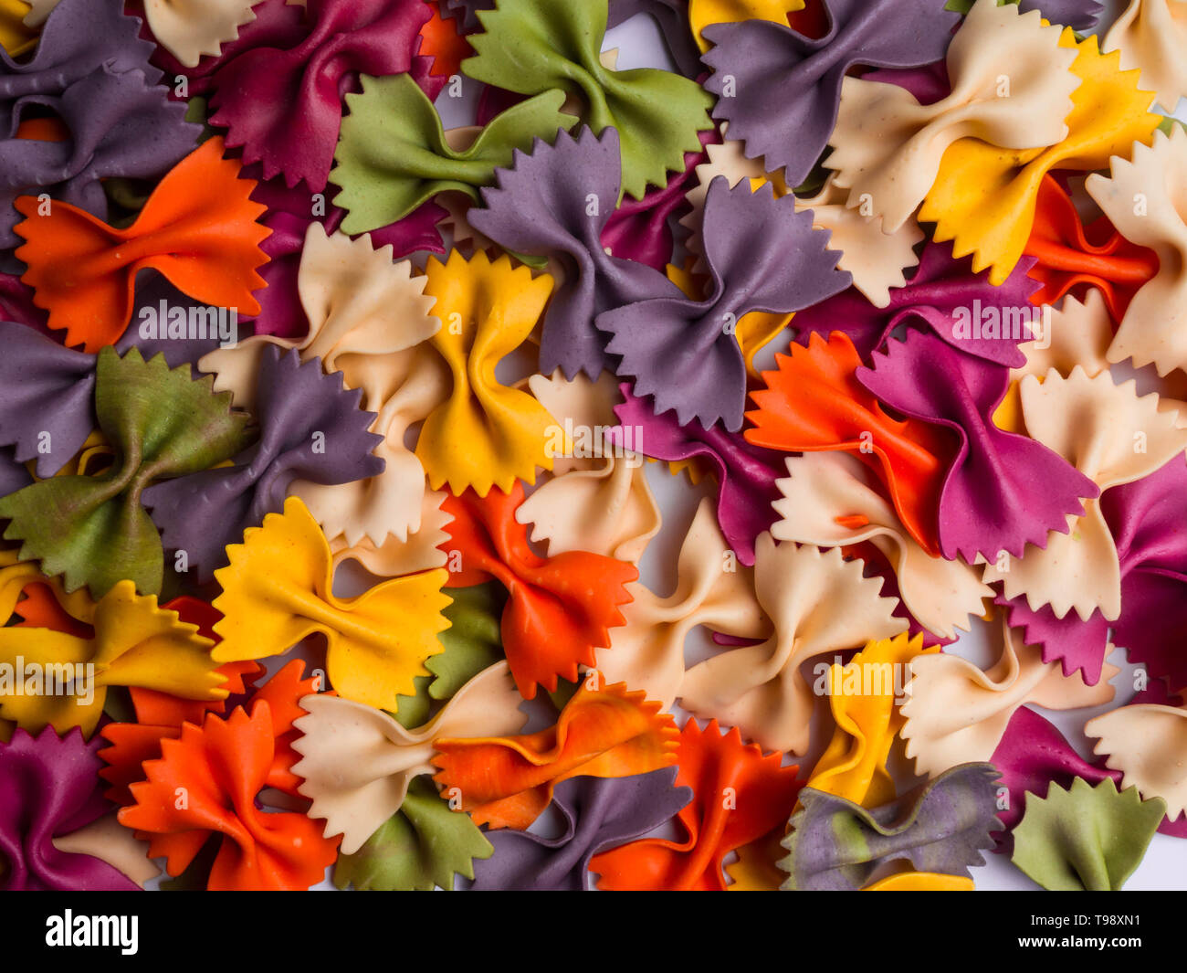 colorful Italian pasta background. Various colors of bow tie farfalle ...