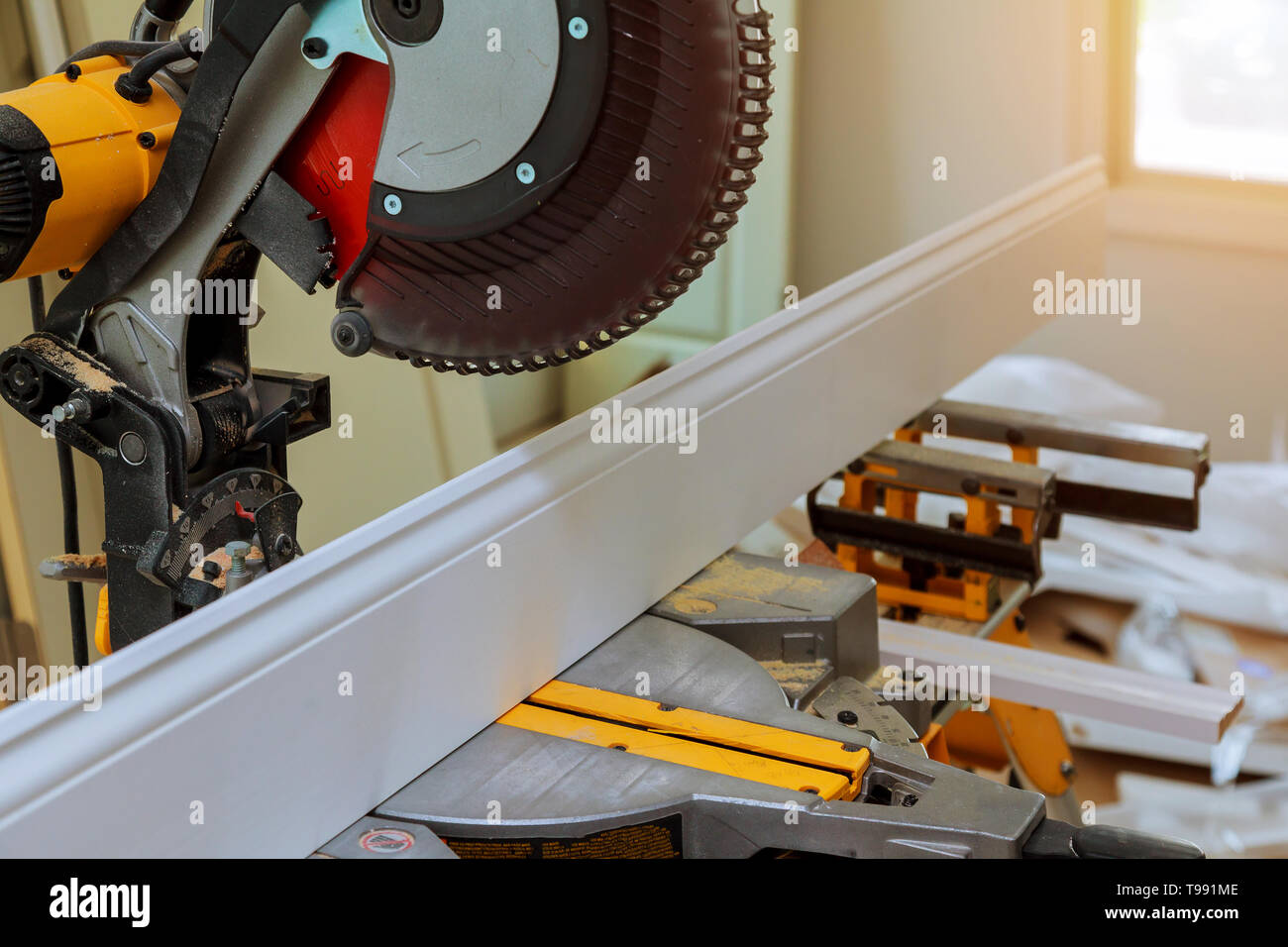 Carpenter working cutting base molding by circular saw Stock Photo - Alamy