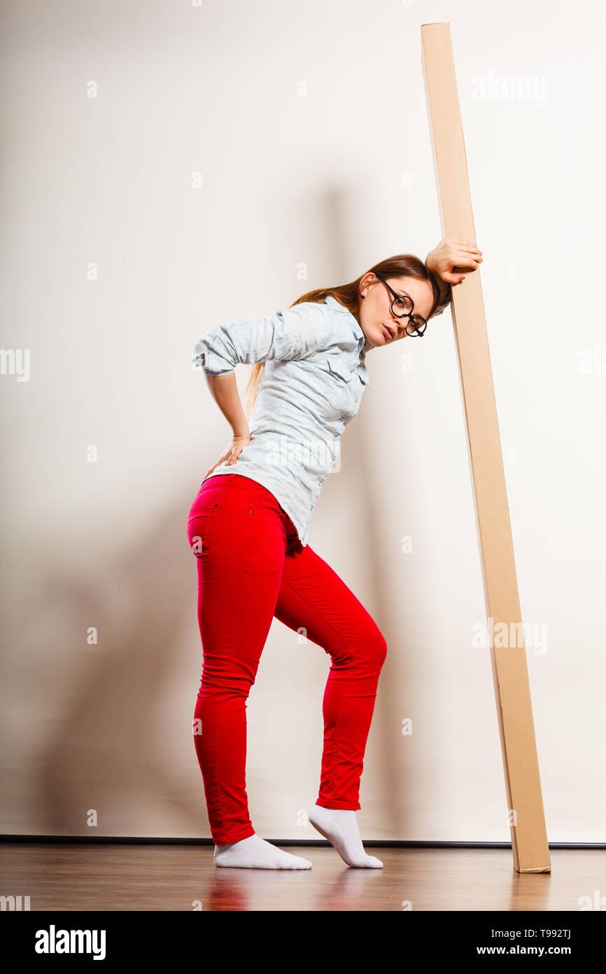 Unhappy tired woman moving into new apartment house carrying heavy ...