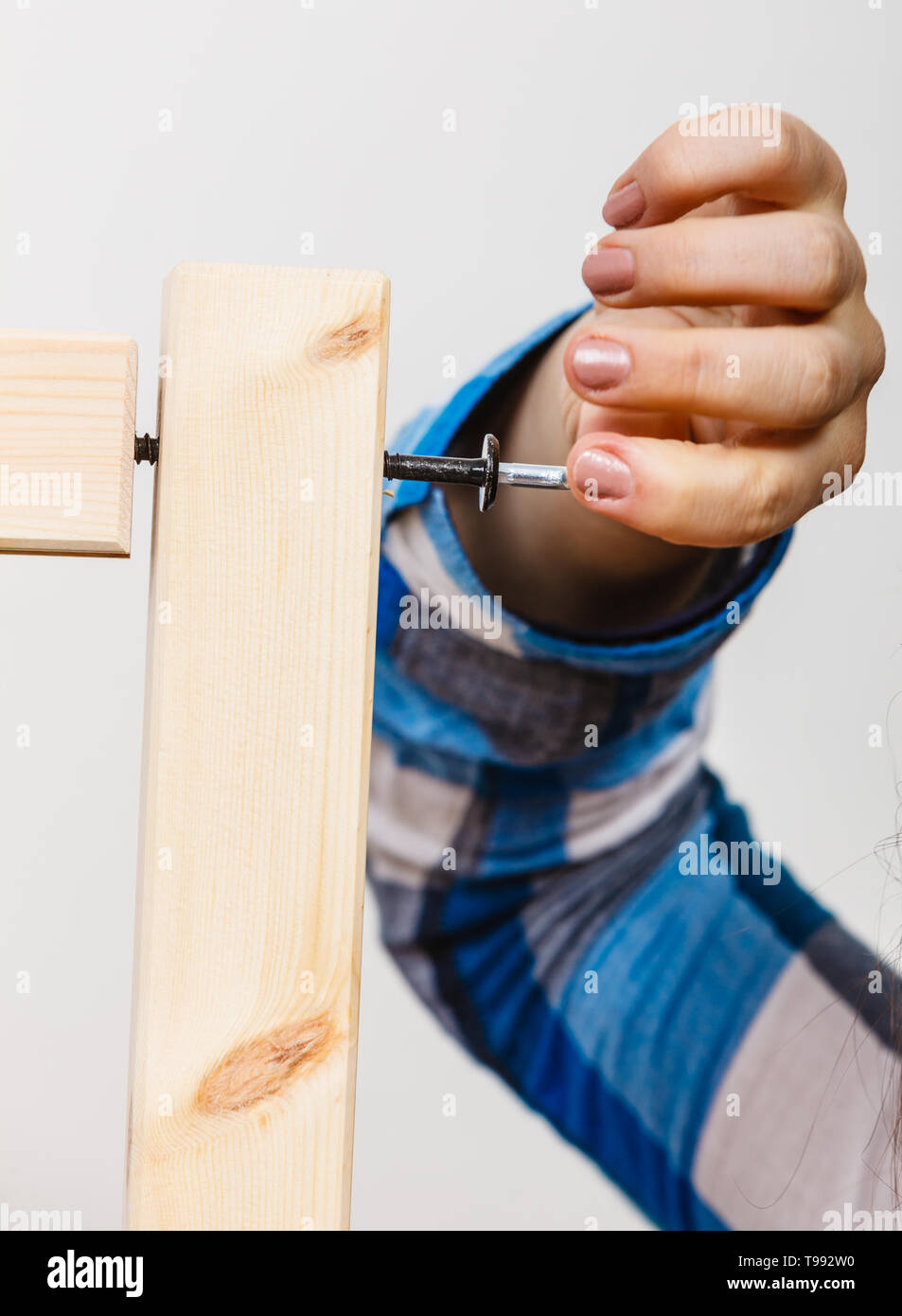 Human hand assembling wood furniture using hex key. DIY enthusiast ...