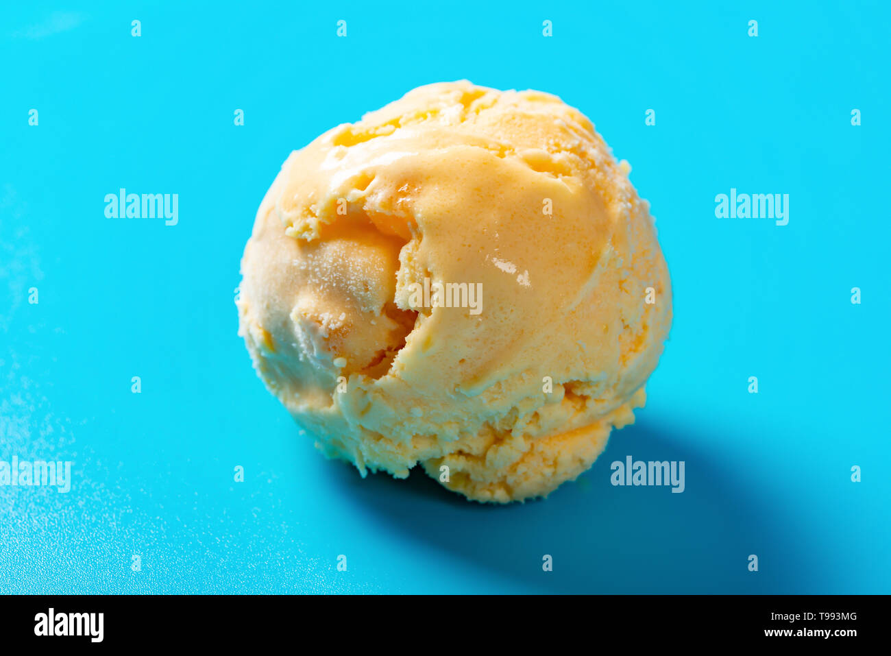 side view mango flavor ice cream ball on blue background Stock Photo ...