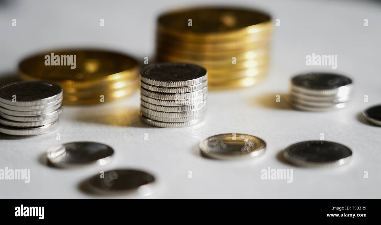 Macro shot detail of golden and silver color coin stacks on dark ...