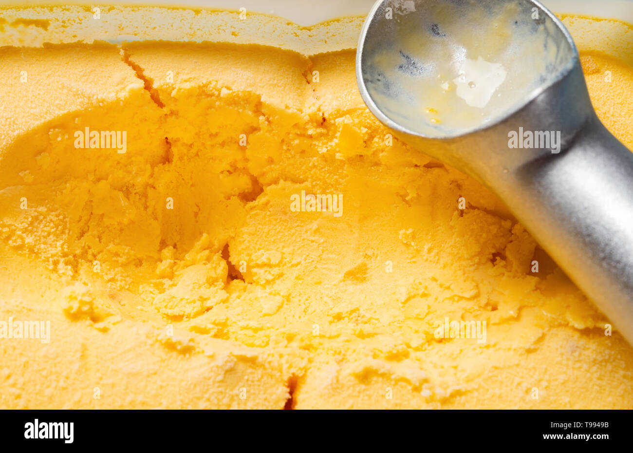 box of mango flavor ice cream with a spoon and some digged out Stock ...