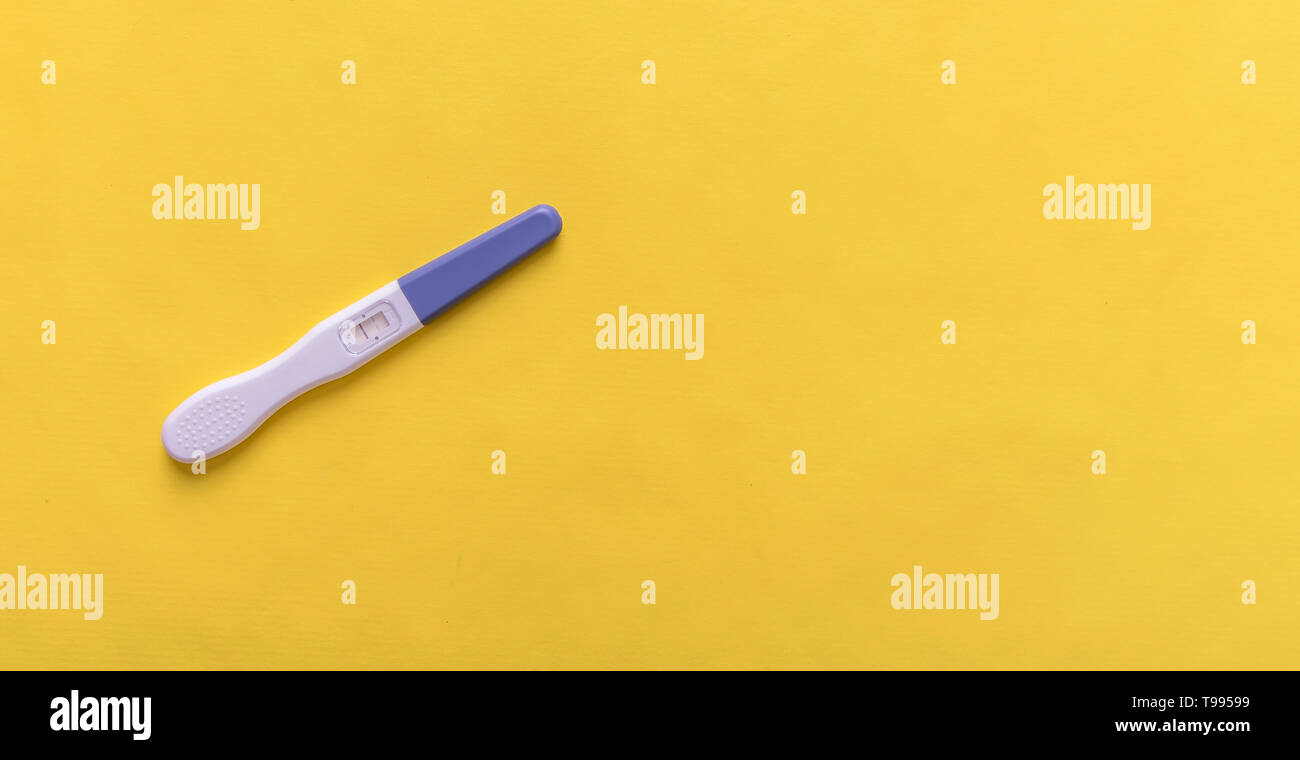 Pregnancy test on yellow background Stock Photo - Alamy