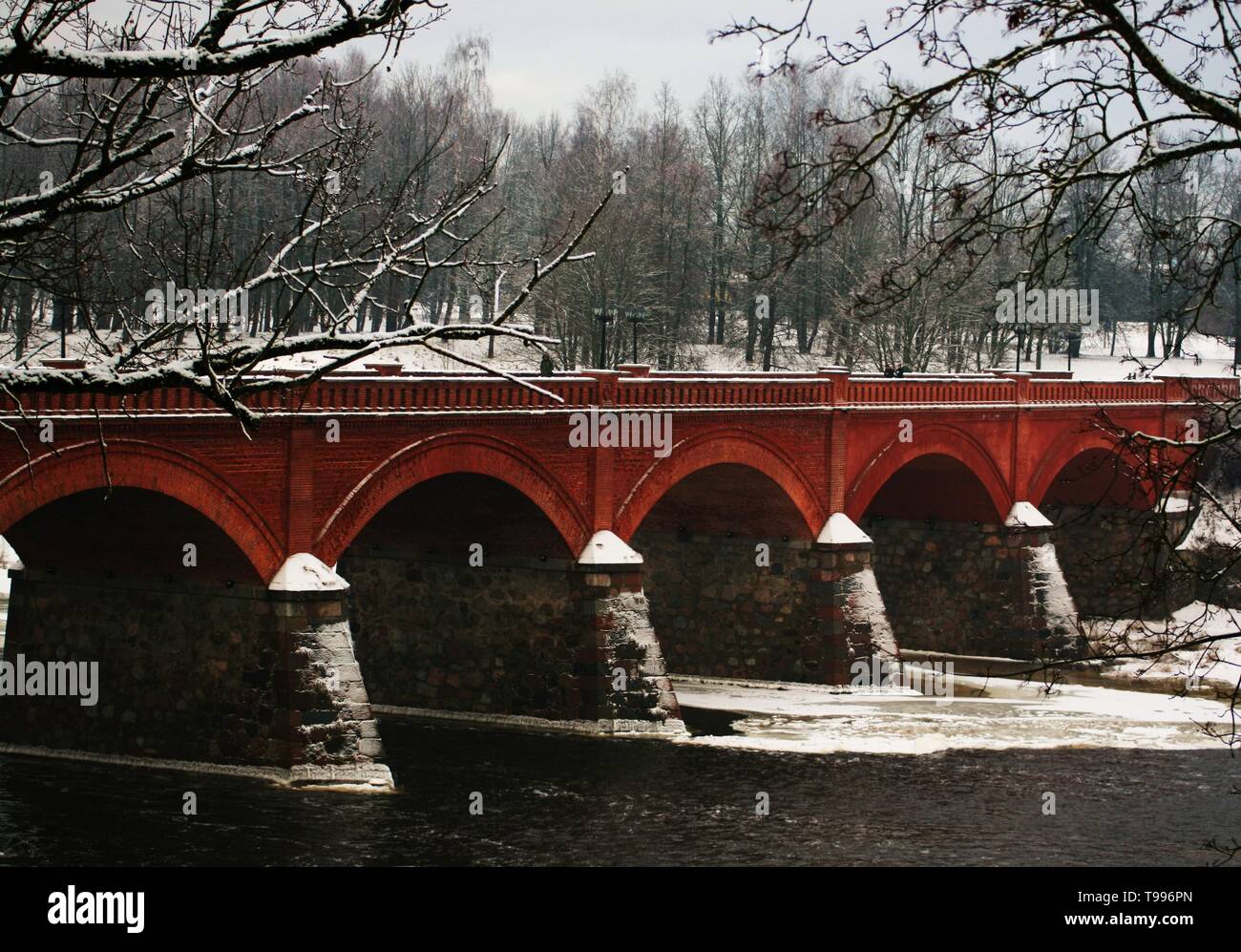 Red brick bridge over partly frozen river Venta in Kuldīga Stock Photo ...