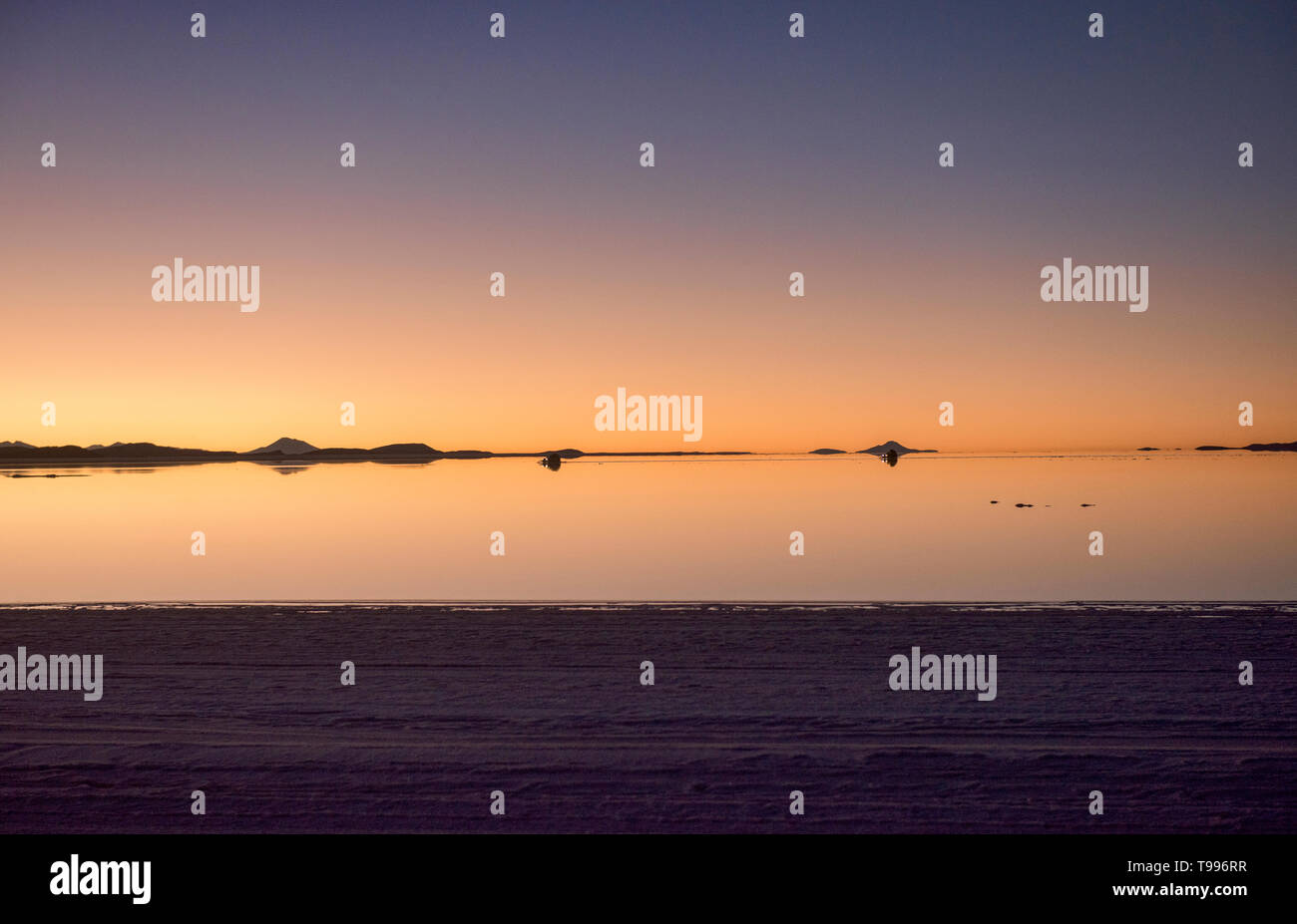 Sunset reflections on the vast salt flat of Salar de Uyuni, Bolivia ...