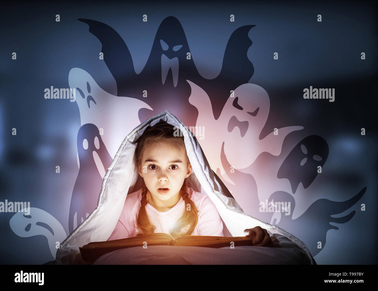 Scared kid with reading book under blanket Stock Photo - Alamy