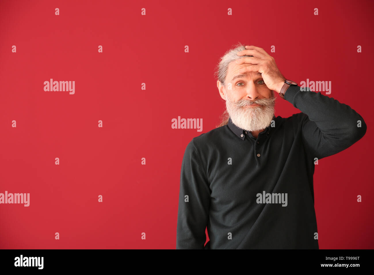 Emotional senior man after making mistake on color background Stock ...