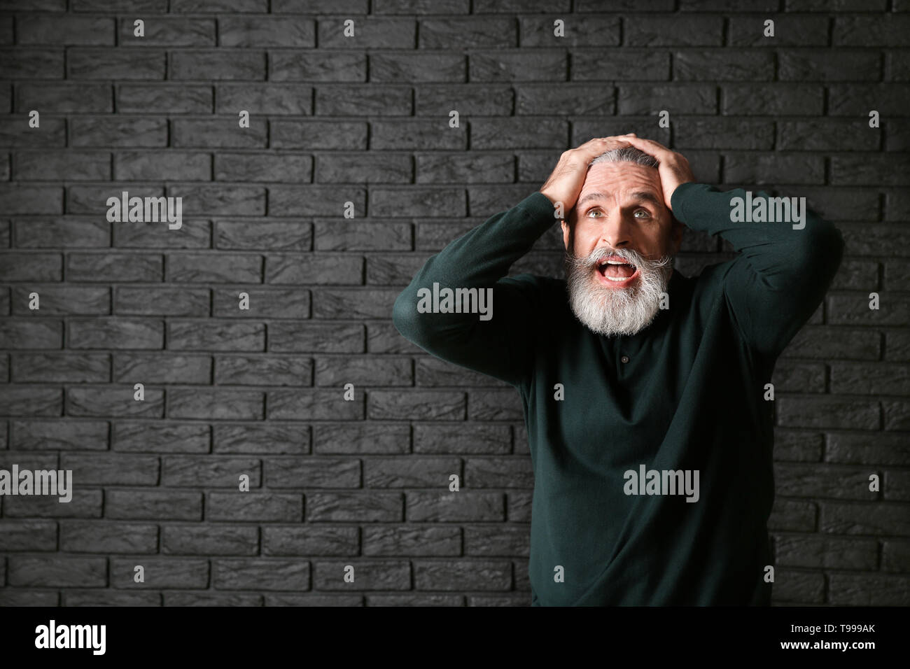 Emotional senior man after making mistake on dark background Stock ...