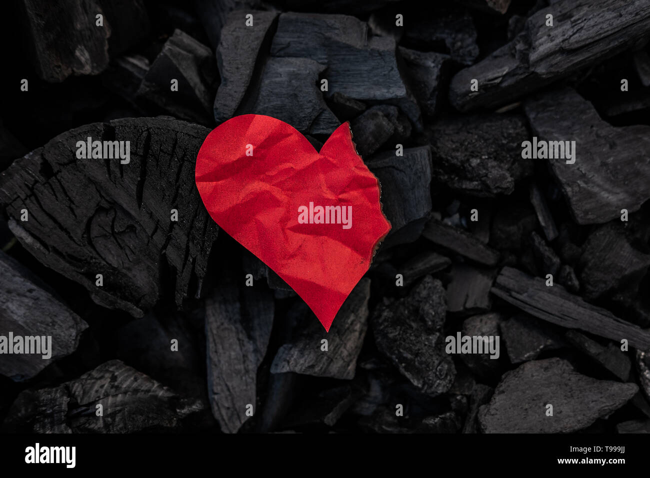 Burning red paper heart on coals minimal background. Sadness ...