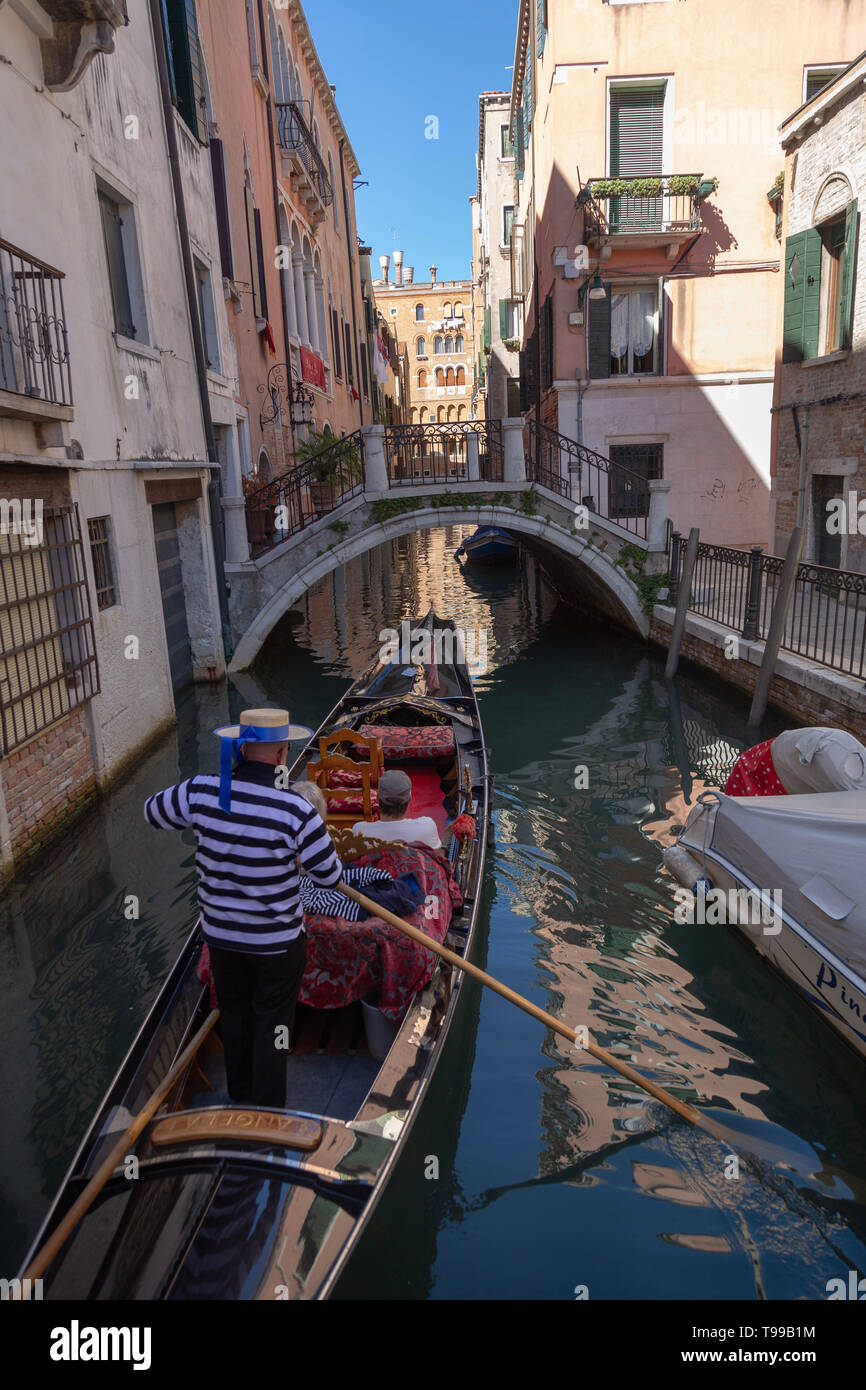 Gondola with gondolier dressed in classic costume while moving in a ...