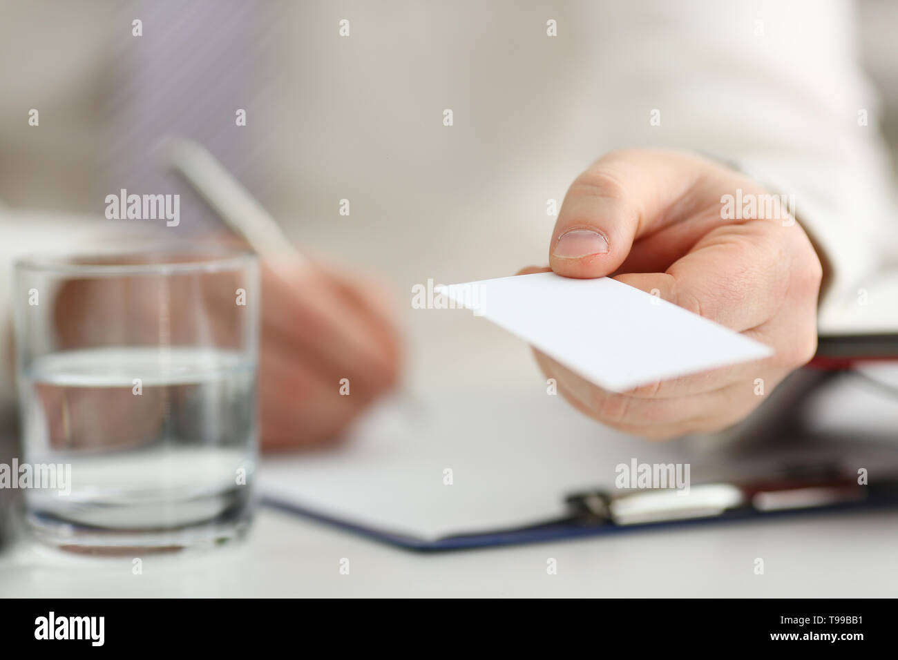 Male arm in suit give blank calling card to visitor Stock Photo - Alamy