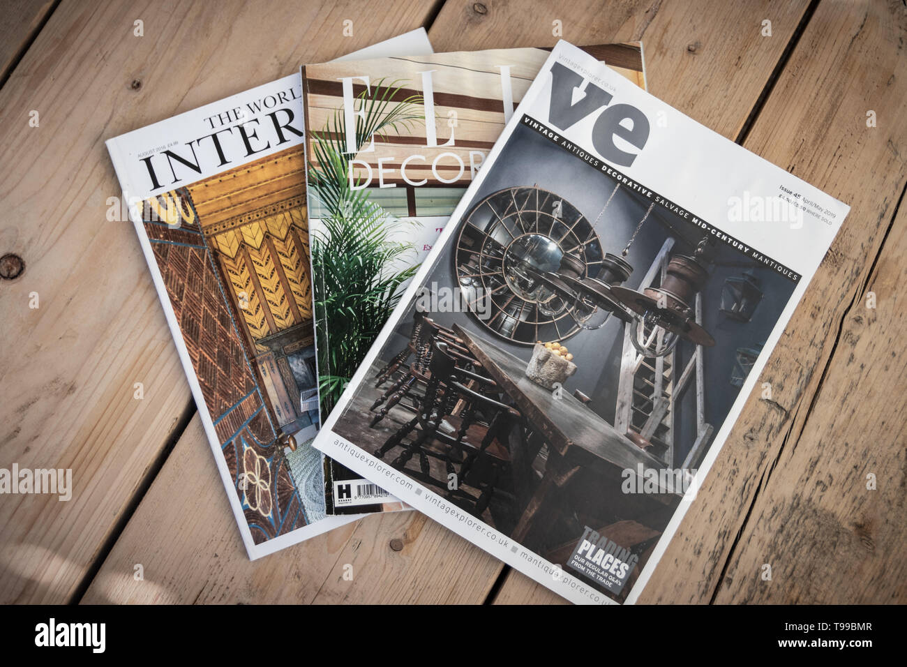 three interior design magazines laid out on a vintage wooden table ...