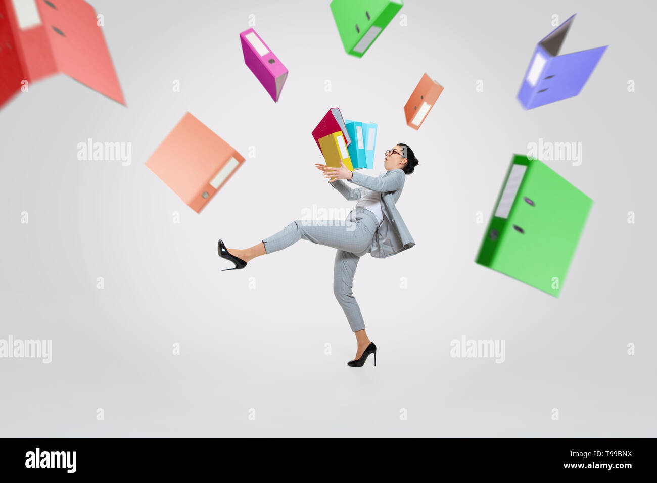 Young woman in suit getting a lot of work and losing concentration ...