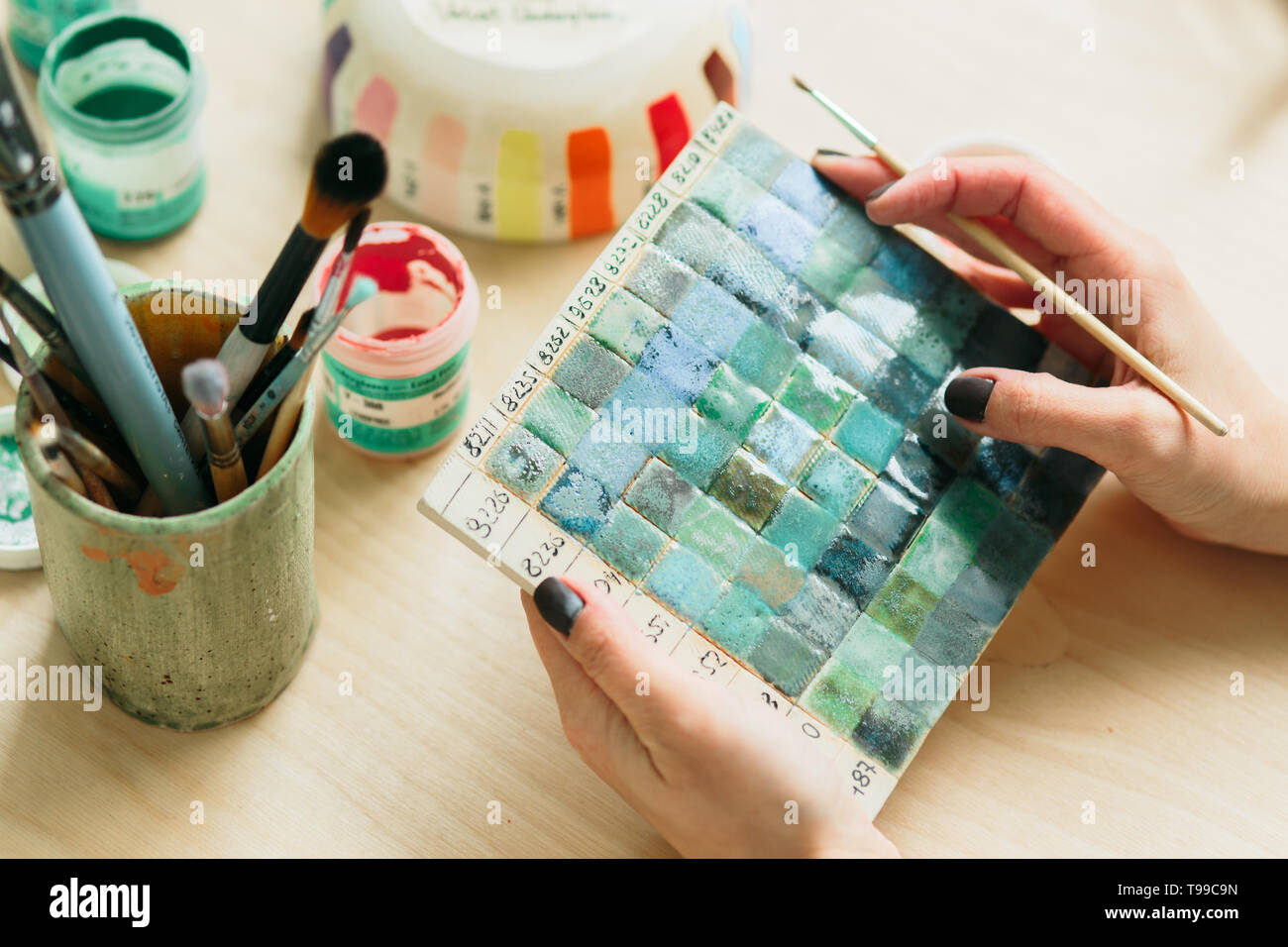 Potter holds the color palette glazes for coating ceramic products on ...