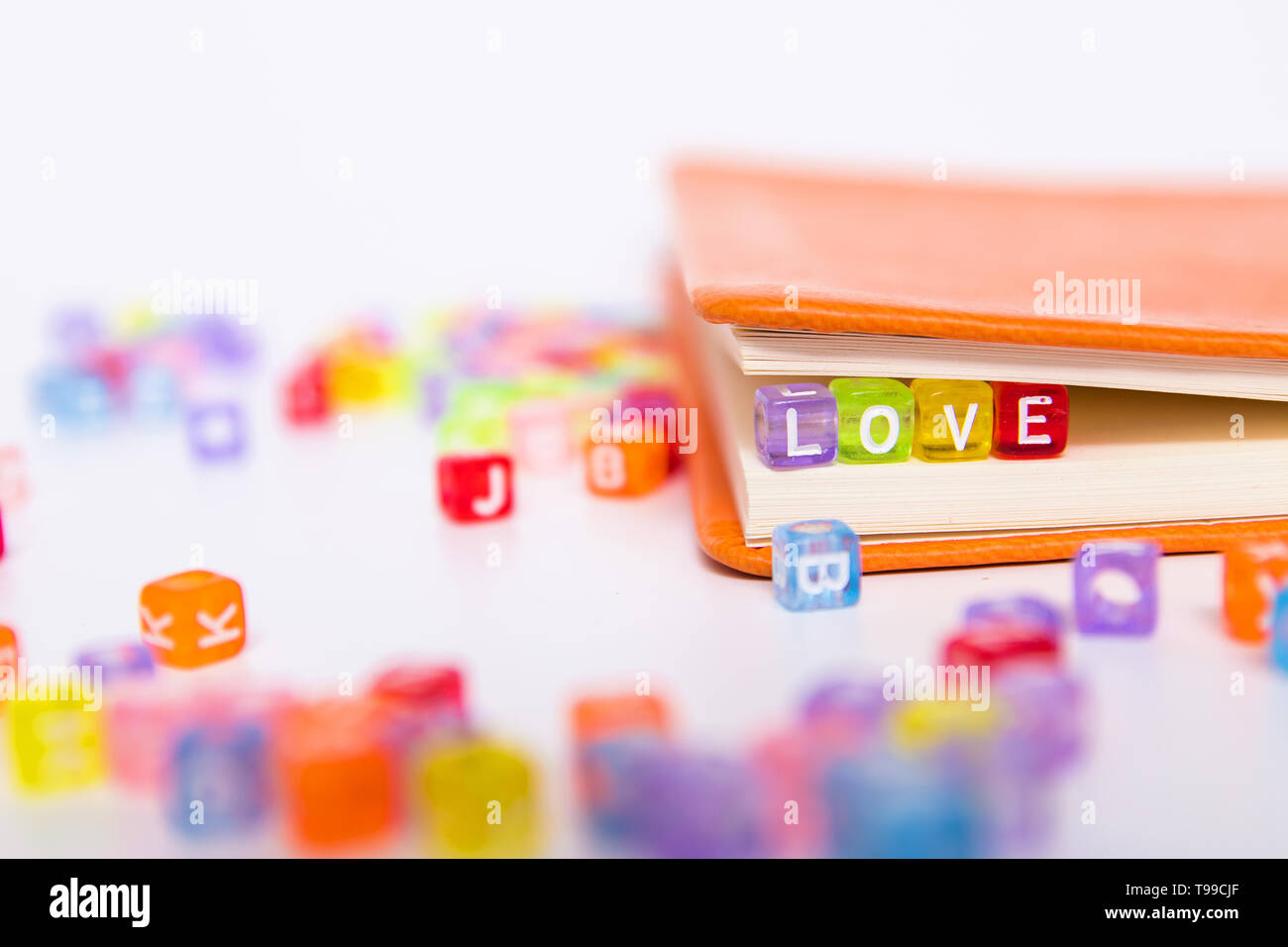 LOVE word on colorful bead block as bookmark in book. Love story ...