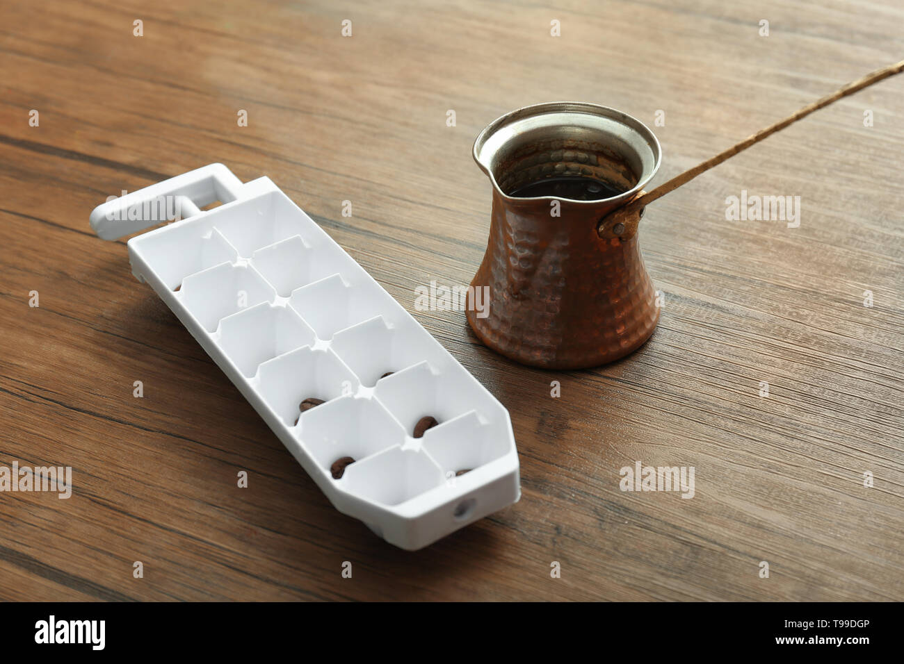 Jezve with coffee and ice tray on table Stock Photo - Alamy