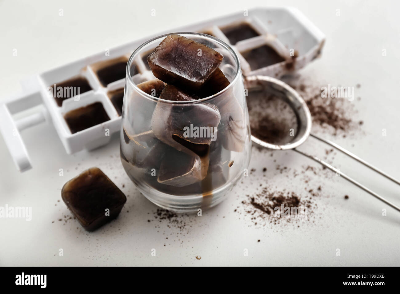 Coffee ice cubes in glass and tray on white background Stock Photo - Alamy