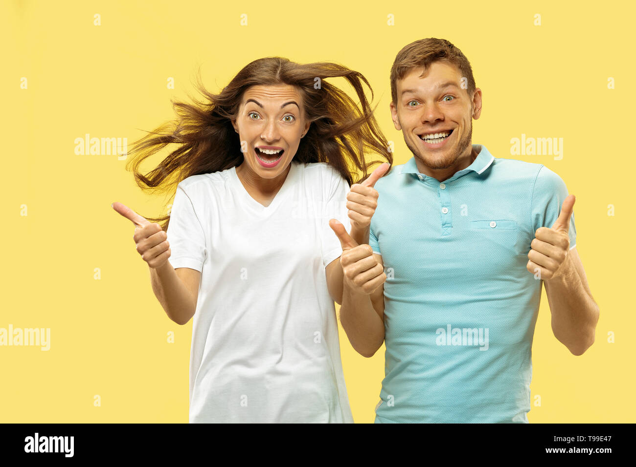 Beautiful young couple's half-length portrait on yellow studio ...