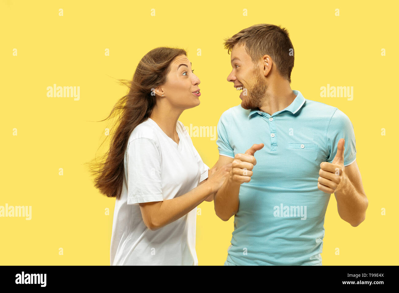 Beautiful young couple's half-length portrait on yellow studio ...