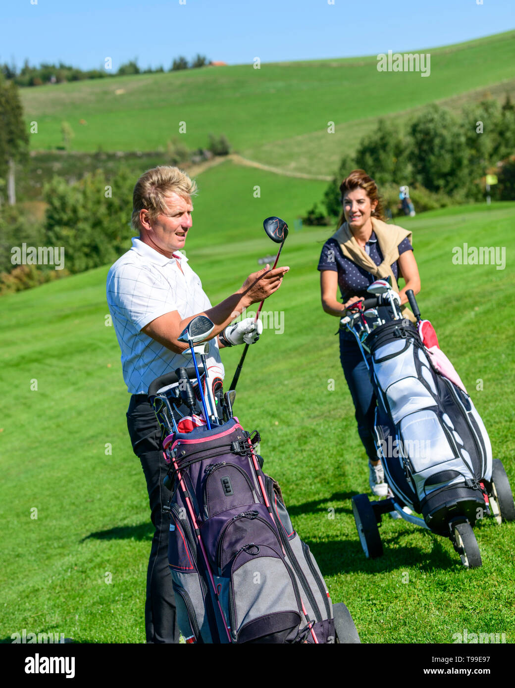 Two golfers on the way on fairway enjoying a golfgame Stock Photo - Alamy