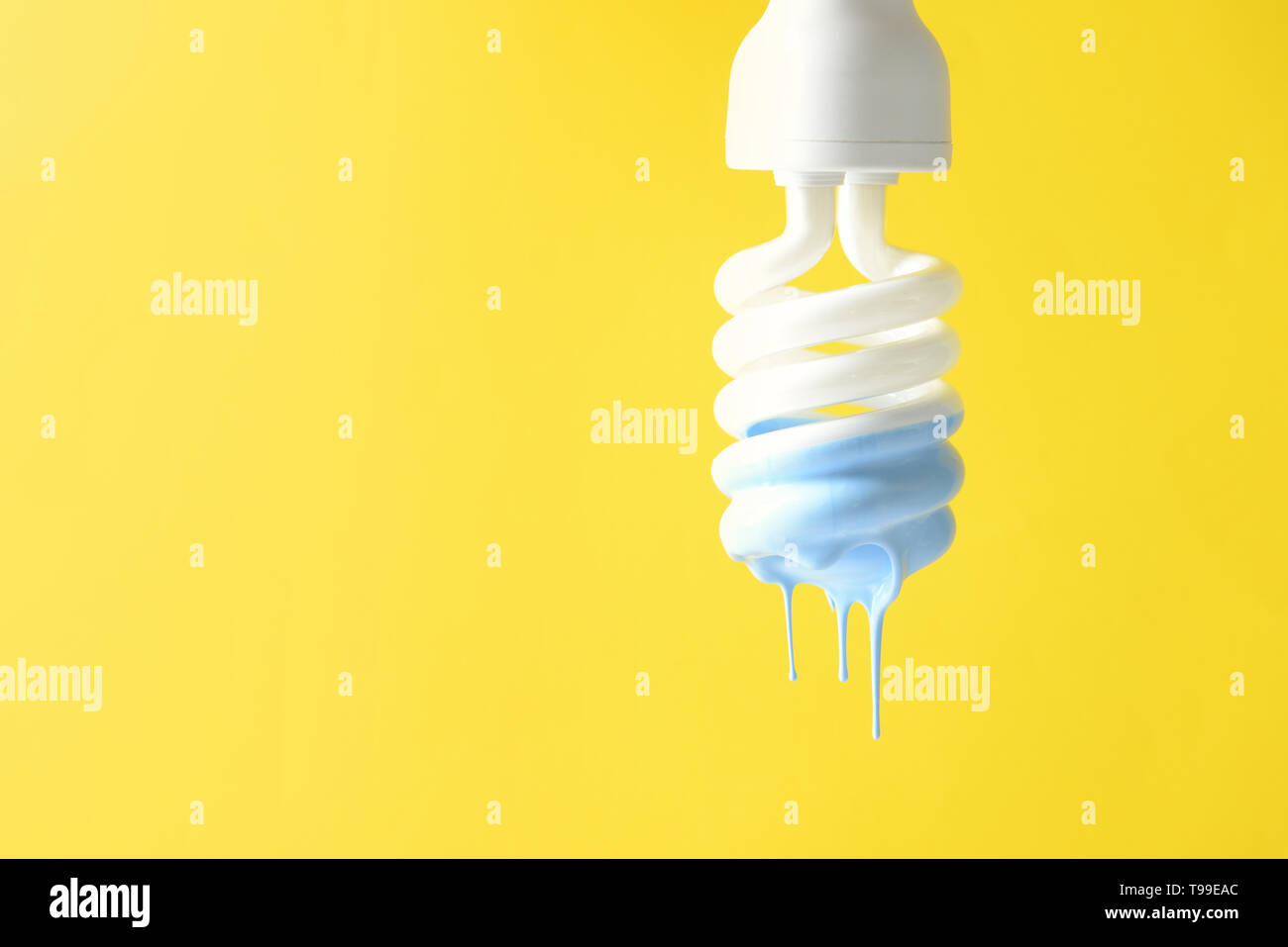 Paint dripping from light bulb on color background Stock Photo - Alamy