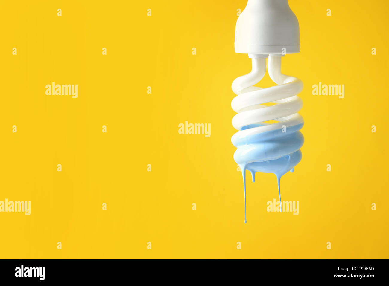Paint dripping from light bulb on color background Stock Photo - Alamy