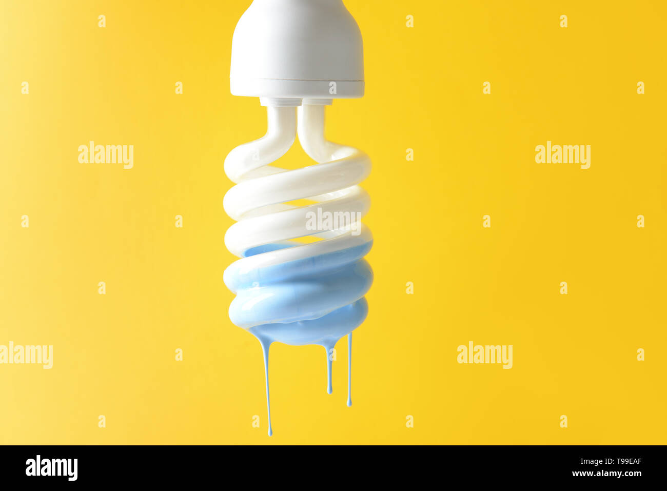 Paint dripping from light bulb on color background Stock Photo - Alamy