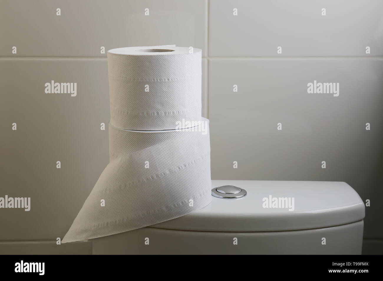 Rolls of soft paper on toilet tank in restroom Stock Photo - Alamy