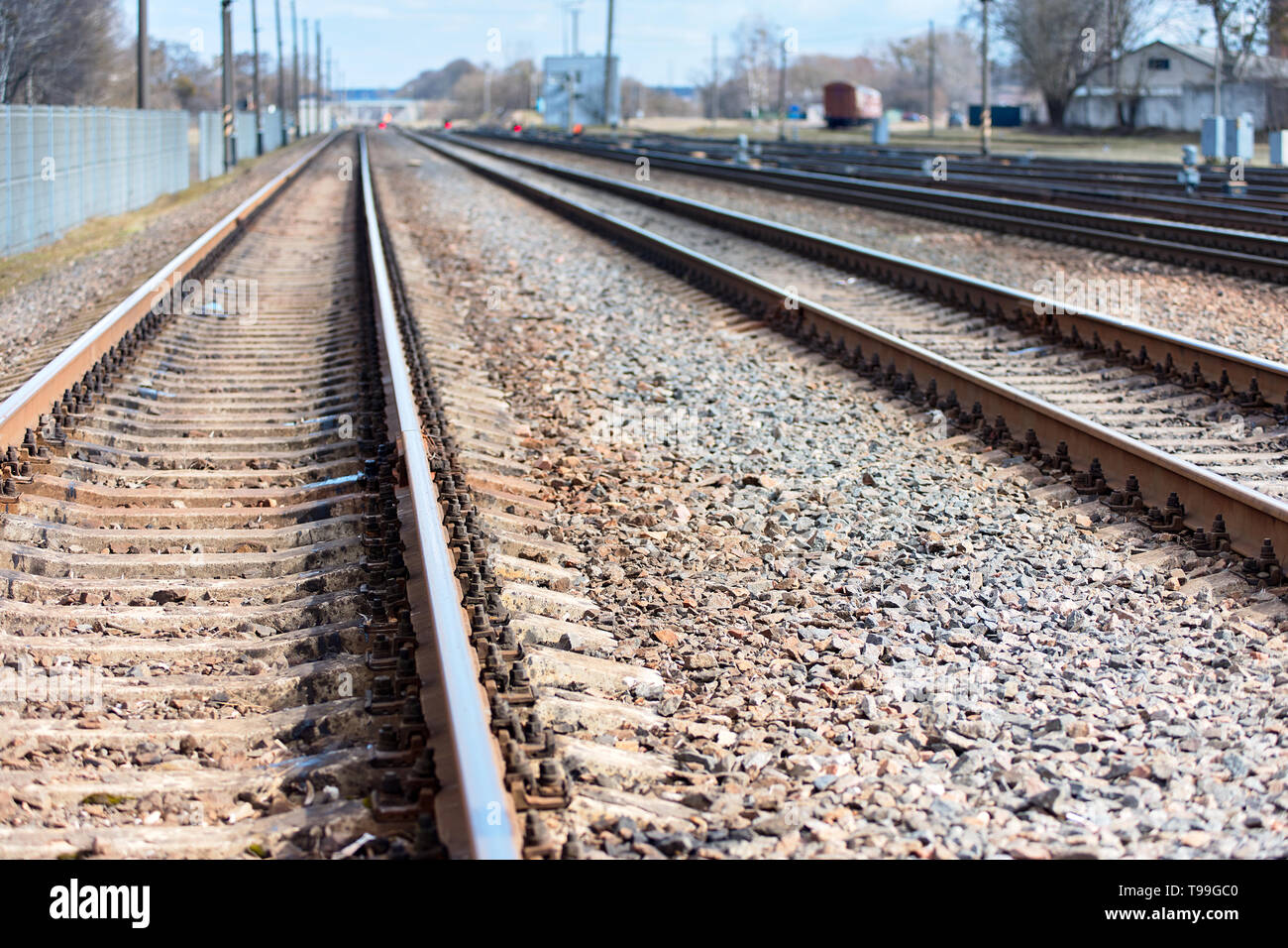Selective focus railway goes straight ahead at sunny spring daytime to ...