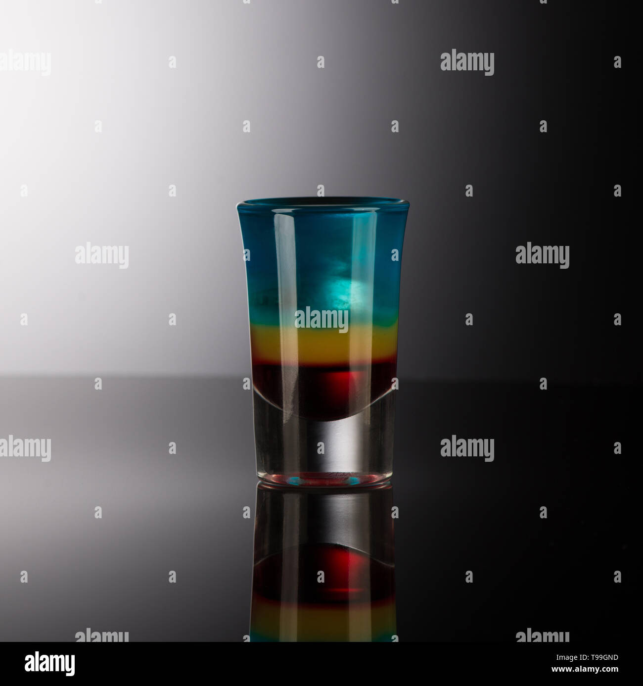 mixed alcoholic liquor in a shot glass isolated on a dark background ...