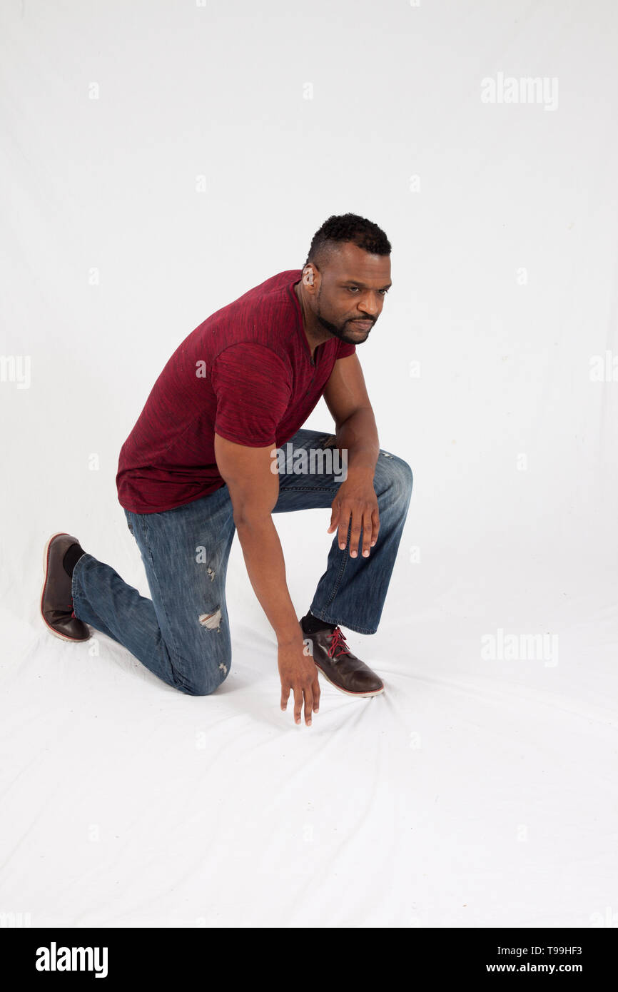 Thoughtful Black man kneeling Stock Photo - Alamy Thoughtful Black man kneeling Stock Photo - Alamy