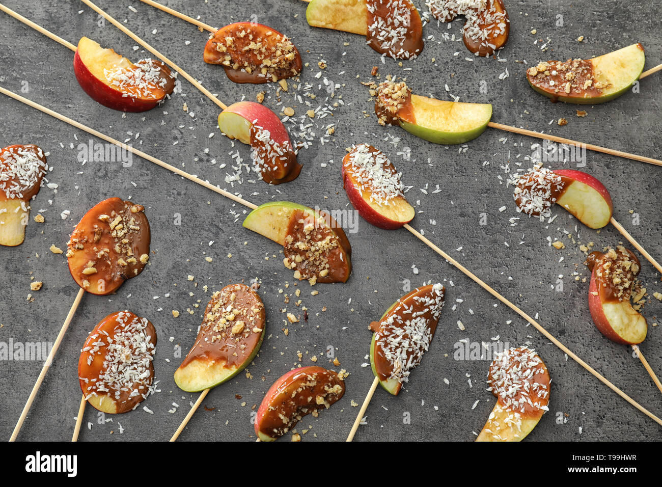 Sticks with candy apple wedges on grey background Stock Photo - Alamy