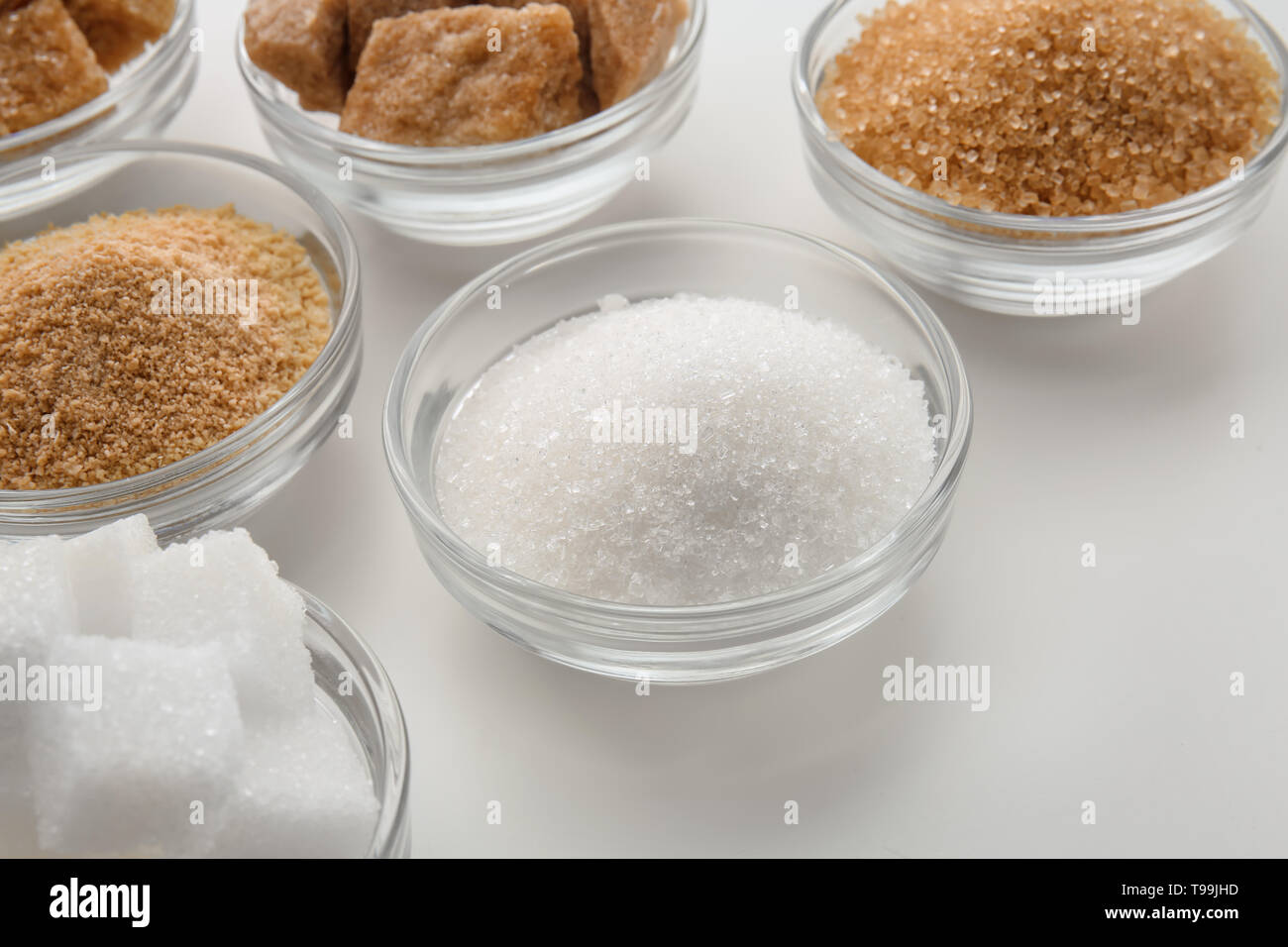 Bowls with different kinds of sugar on white background Stock Photo - Alamy