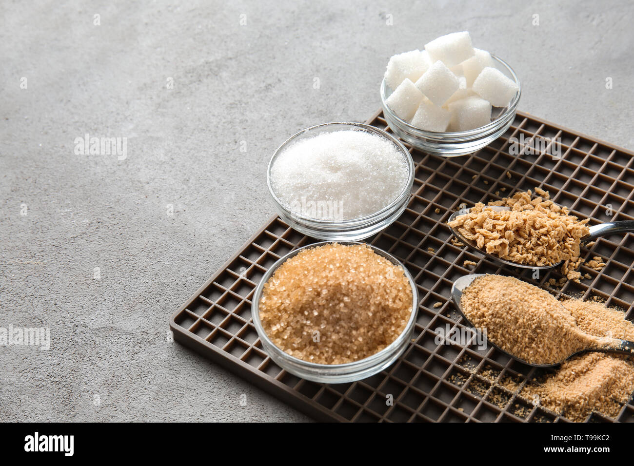 Different kinds of sugar on grey table Stock Photo - Alamy