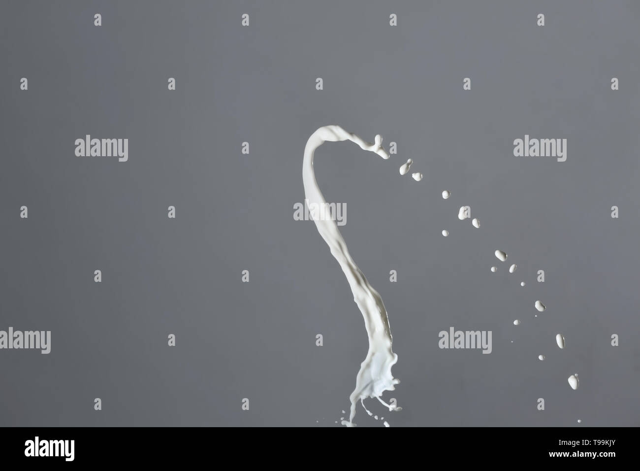 Splash of milk on grey background Stock Photo - Alamy