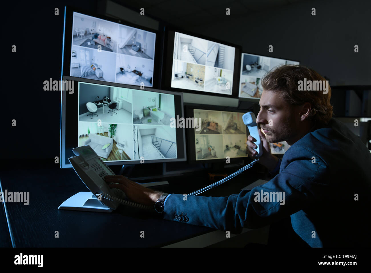 Security guard monitoring modern CCTV cameras in surveillance room ...