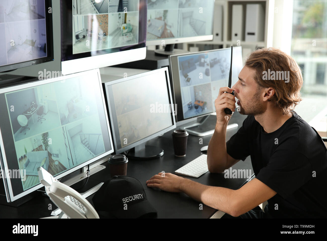 Security guard monitoring modern CCTV cameras in surveillance room ...