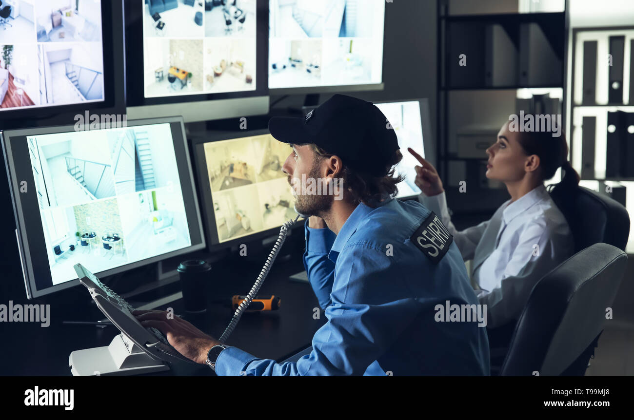Security guards monitoring modern CCTV cameras in surveillance room ...