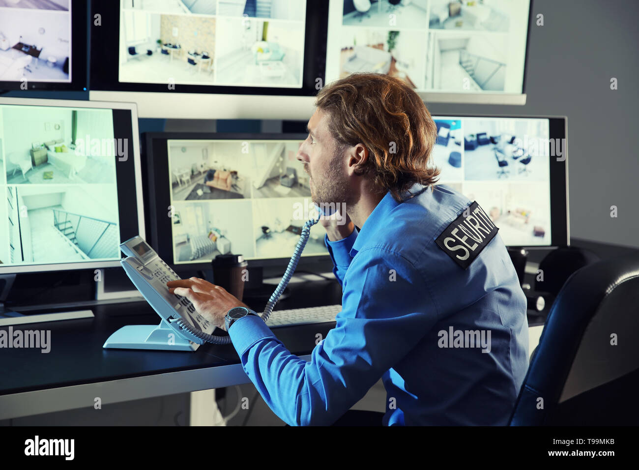 Security guard monitoring modern CCTV cameras in surveillance room ...