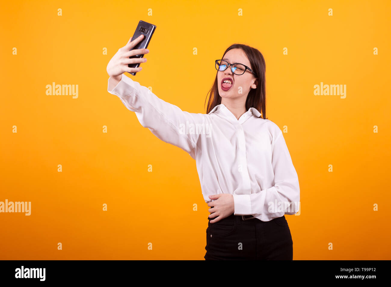 Pretty young teenage girl making silly face and taking a selfie in ...
