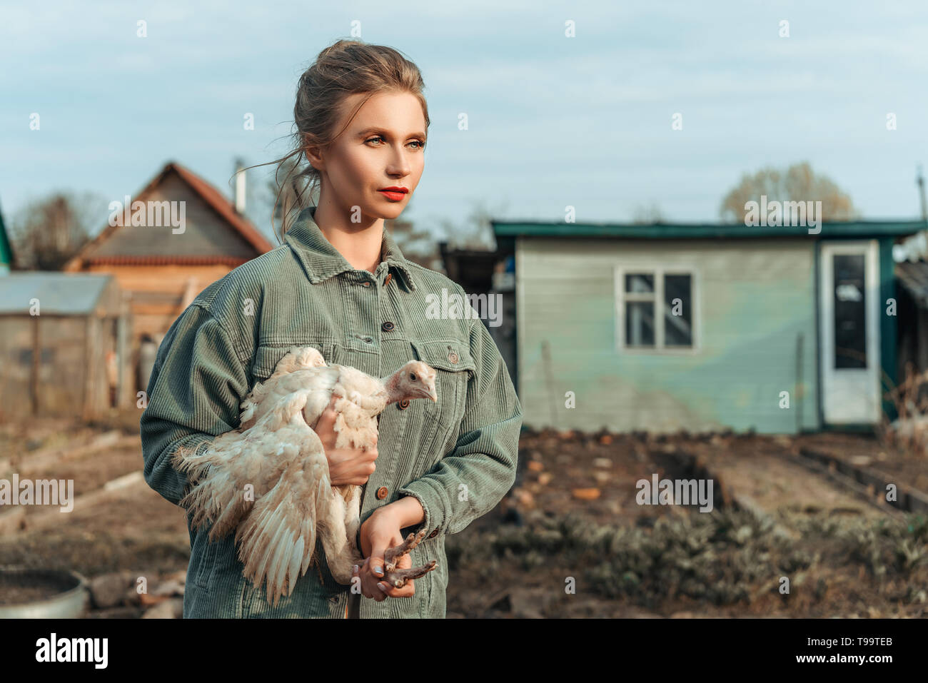 beautiful woman with a chicken in her hands Stock Photo - Alamy