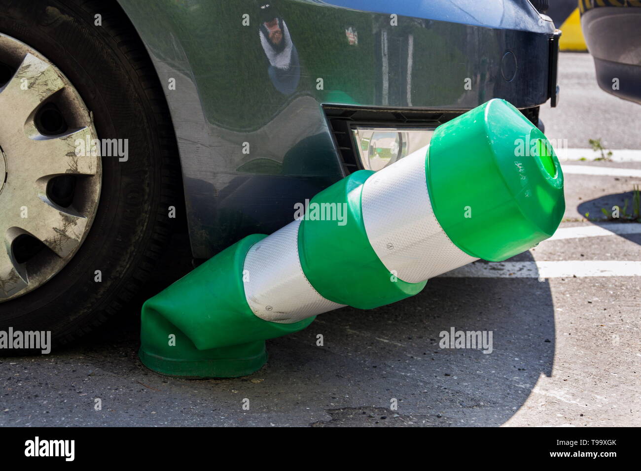 Car bending white and green safety traffic post with front bumper ...