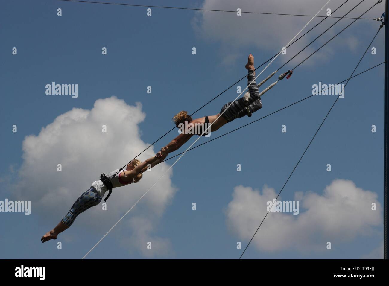 Trapeze artists swinging through the air Stock Photo - Alamy