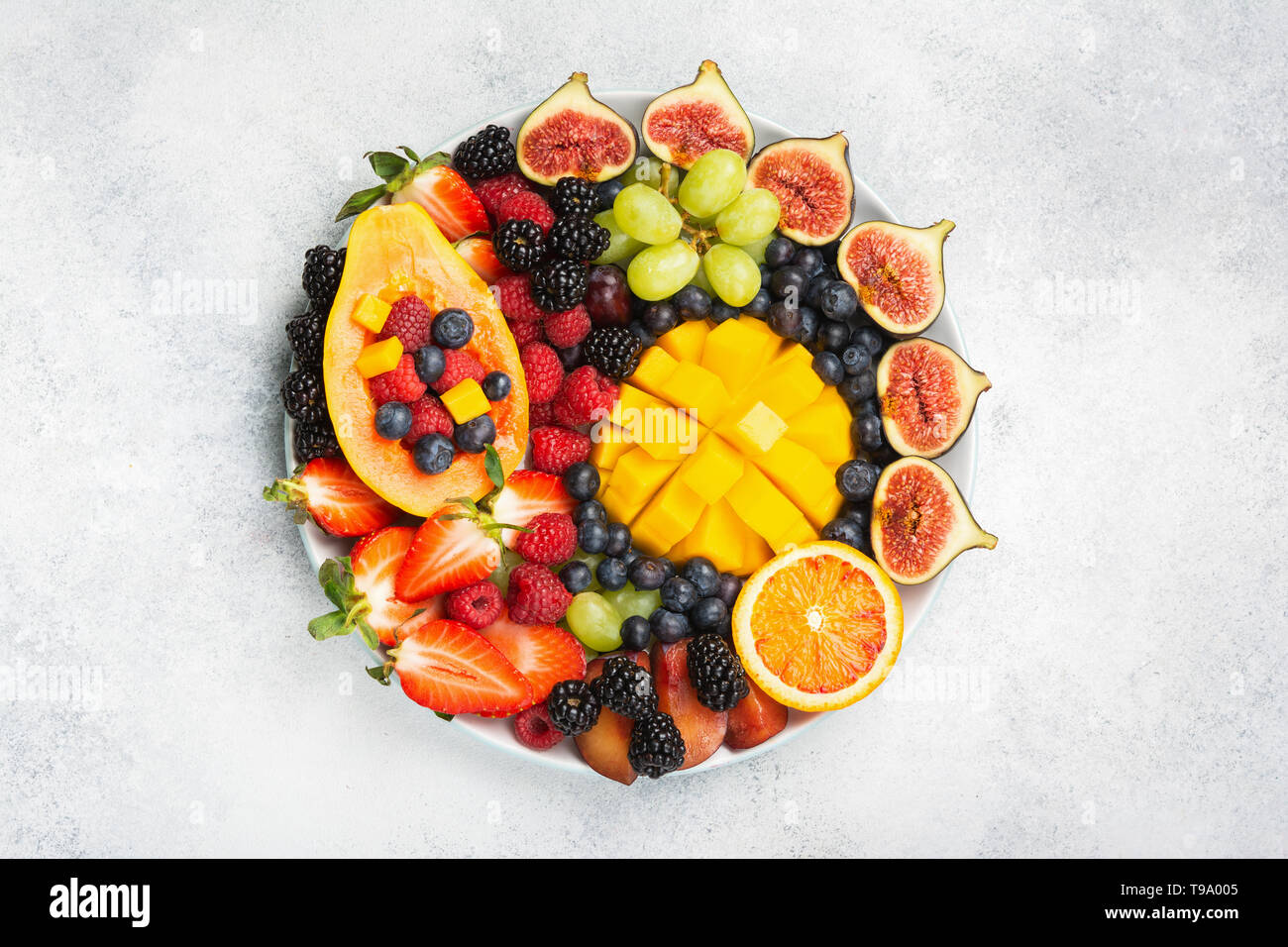 Delicious fruit platter mango papaya oranges figs berries on round ...