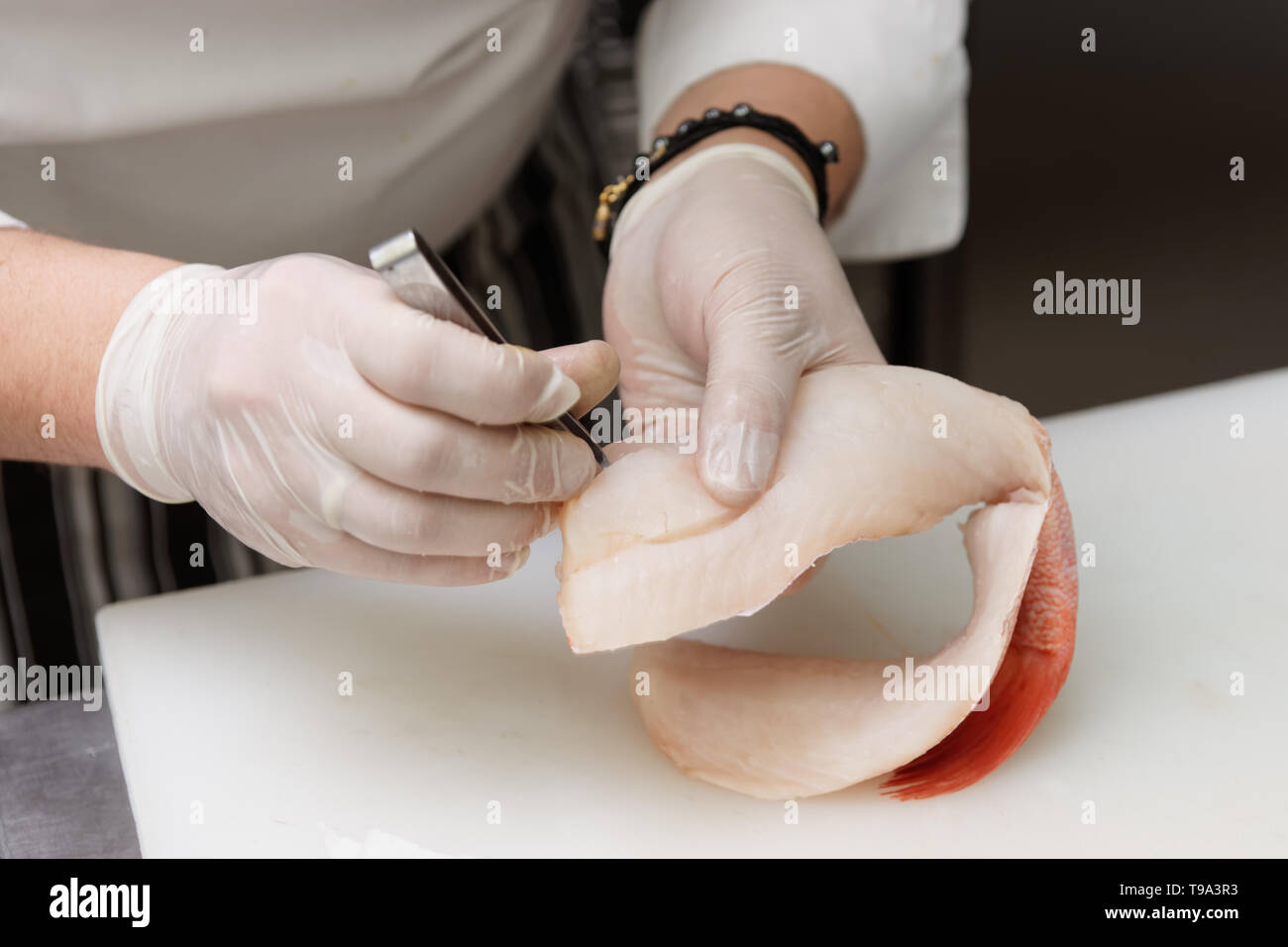 Chef is removing bones from fish fillet, restaurant kitchen Stock Photo ...