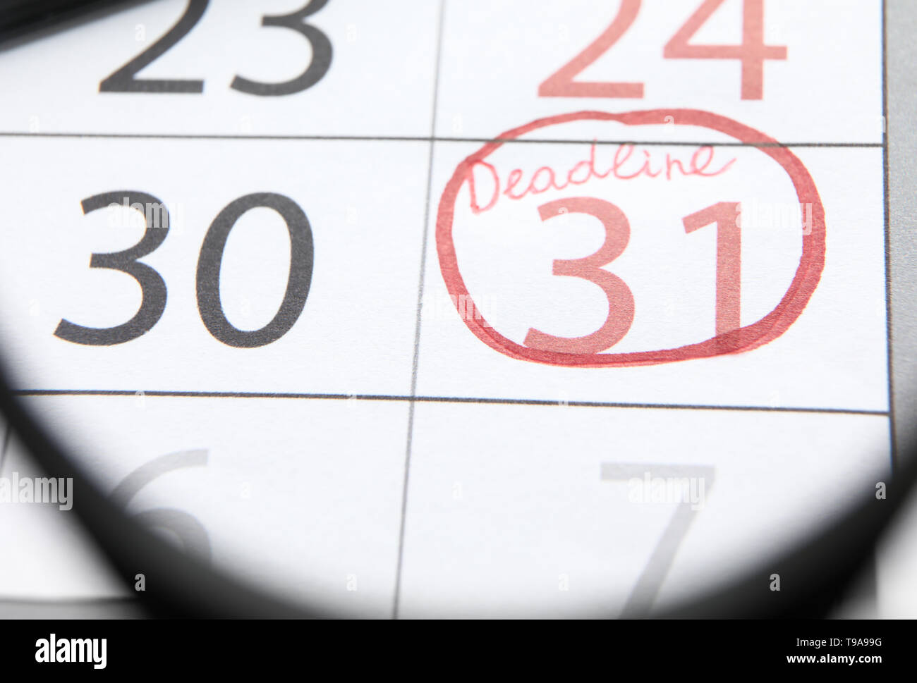 View through magnifying glass on calendar with date reminder. Deadline ...
