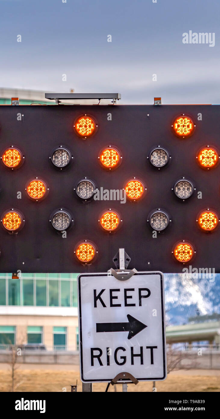 Vertical Close up of an arrow board and Keep Right sign against a ...
